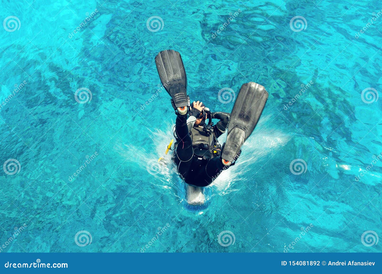 Diver in a Wetsuit and Flippers Jumping in the Blue Water Stock Photo ...