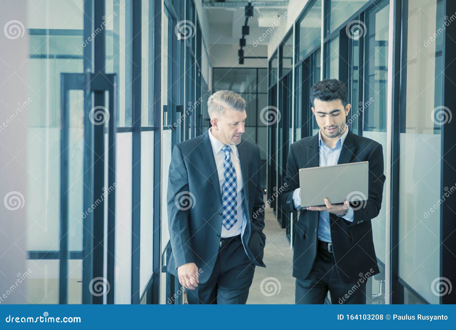 Diverse Business People Using Laptop Together while Walking Stock Photo ...