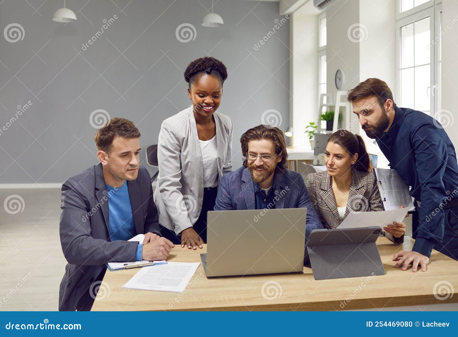 Diverse Team of Happy People Use a Laptop and Tablet while Working on a ...