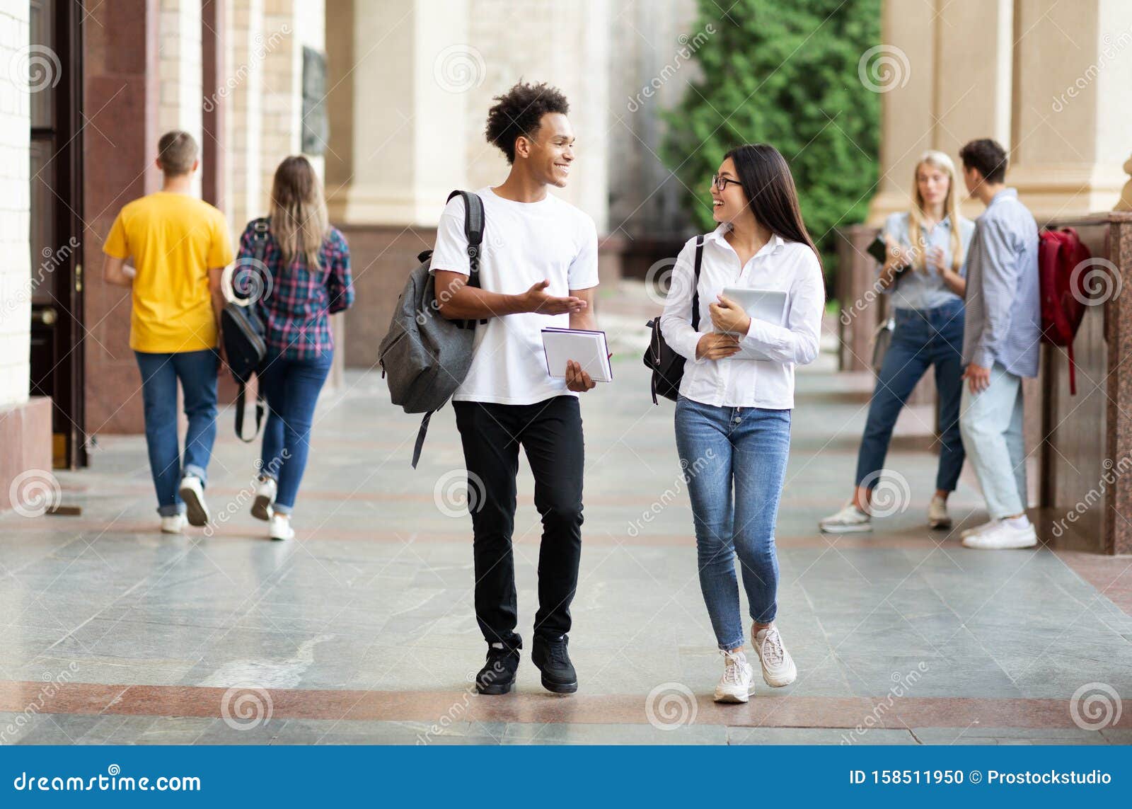 Diverse Classmates Chatting, Walking after Classes Outdoors Stock Photo ...