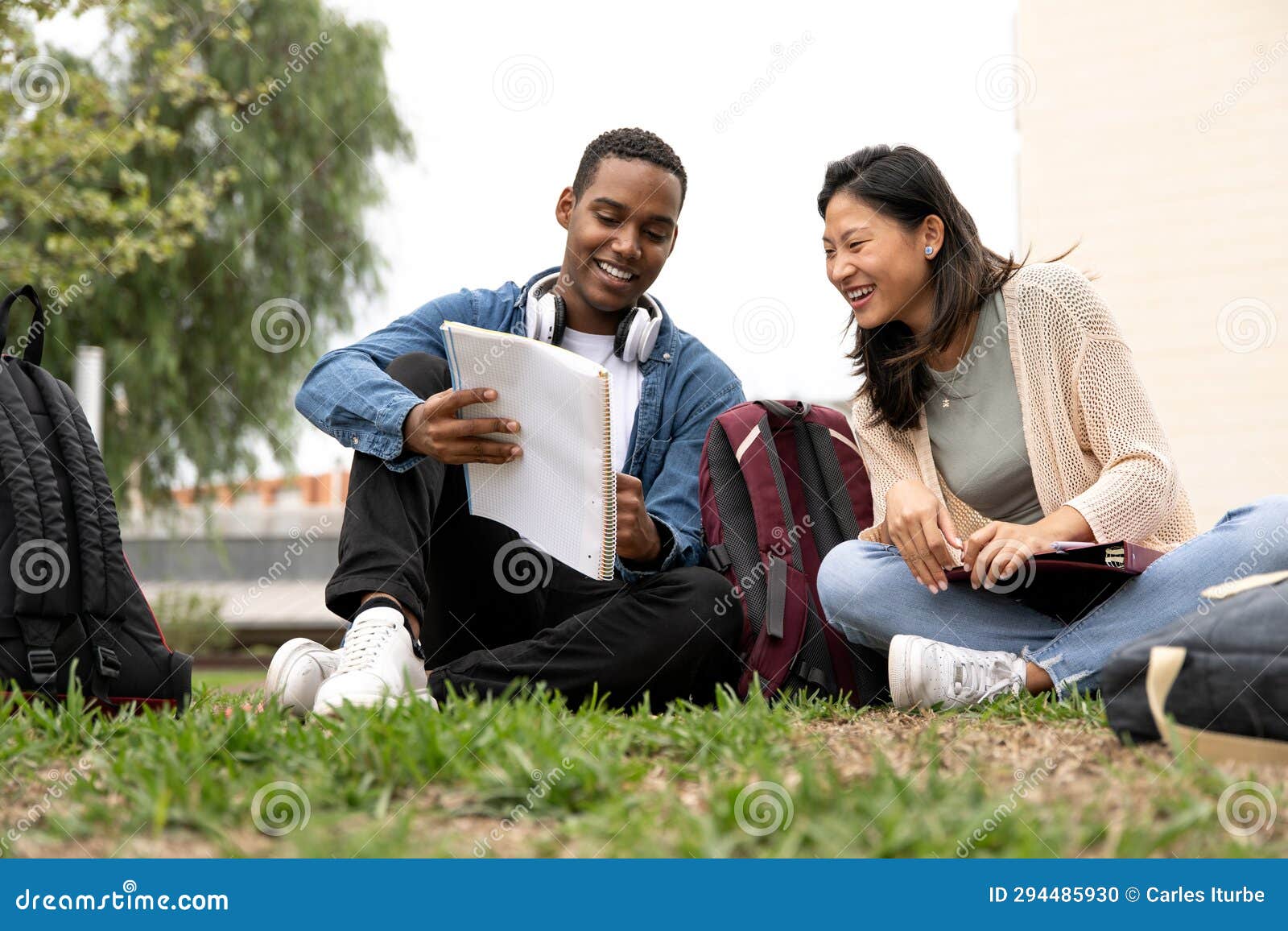 Diverse Couple of Students Sitting Outside Reading Documents.Two Young ...