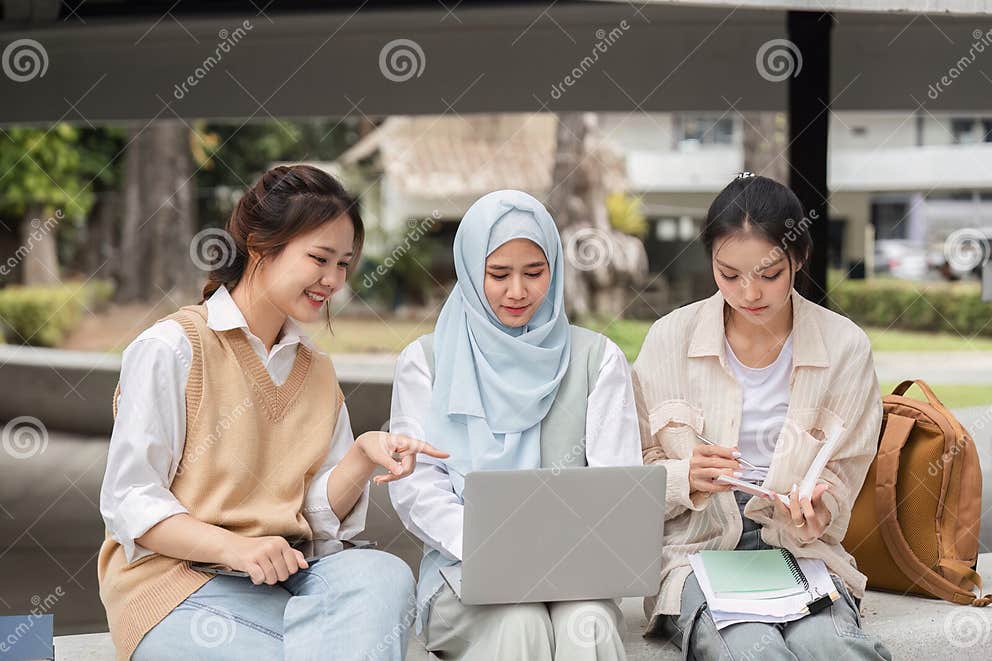 Diverse Female Students Studying Together with a Laptop and Notebooks in a Campus Environment ...