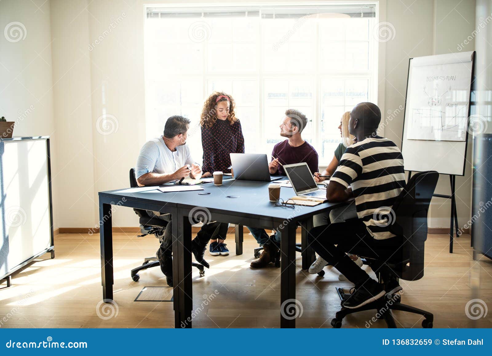 Diverse Group of Designers Talking Together Around an Office Tab Stock ...