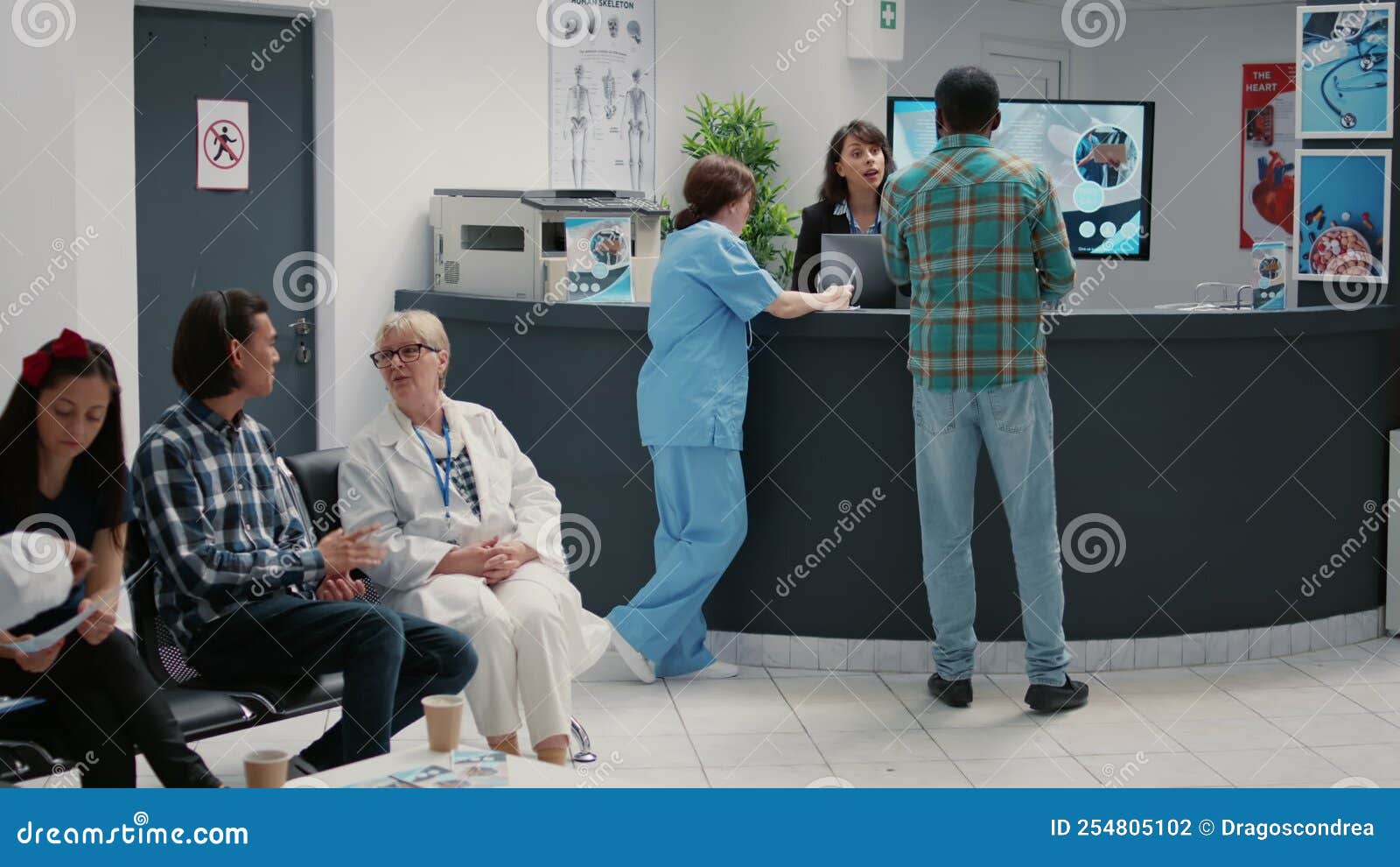 Diverse Group Of Patients Sitting In Waiting Room Area To Register For Appointment Stock Footage