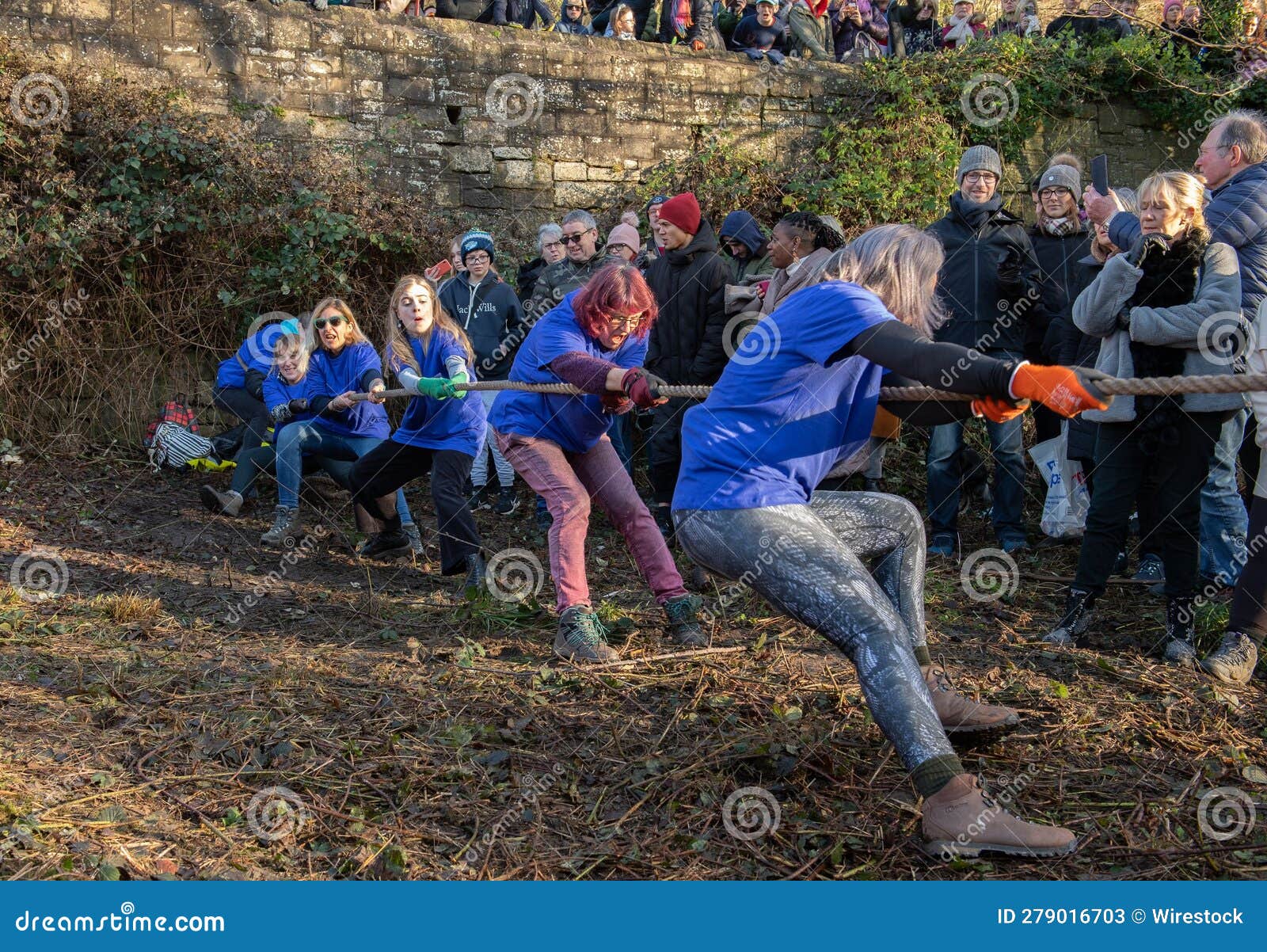 Diverse Group Of People Working Together To Pull A Rope During A Game ...