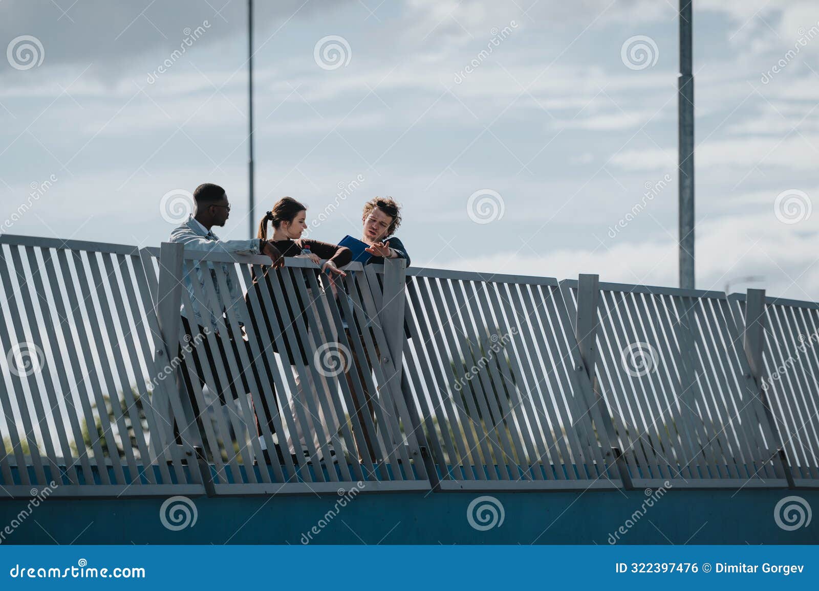 Three Friends Chatting Casually on a Bridge on a Sunny Day Stock Photo ...