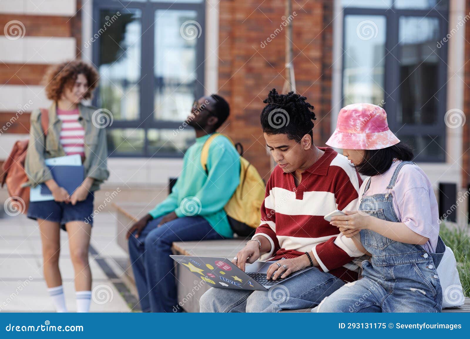 Diverse Group of Young Students Sitting in Row Outdoors and Studying ...