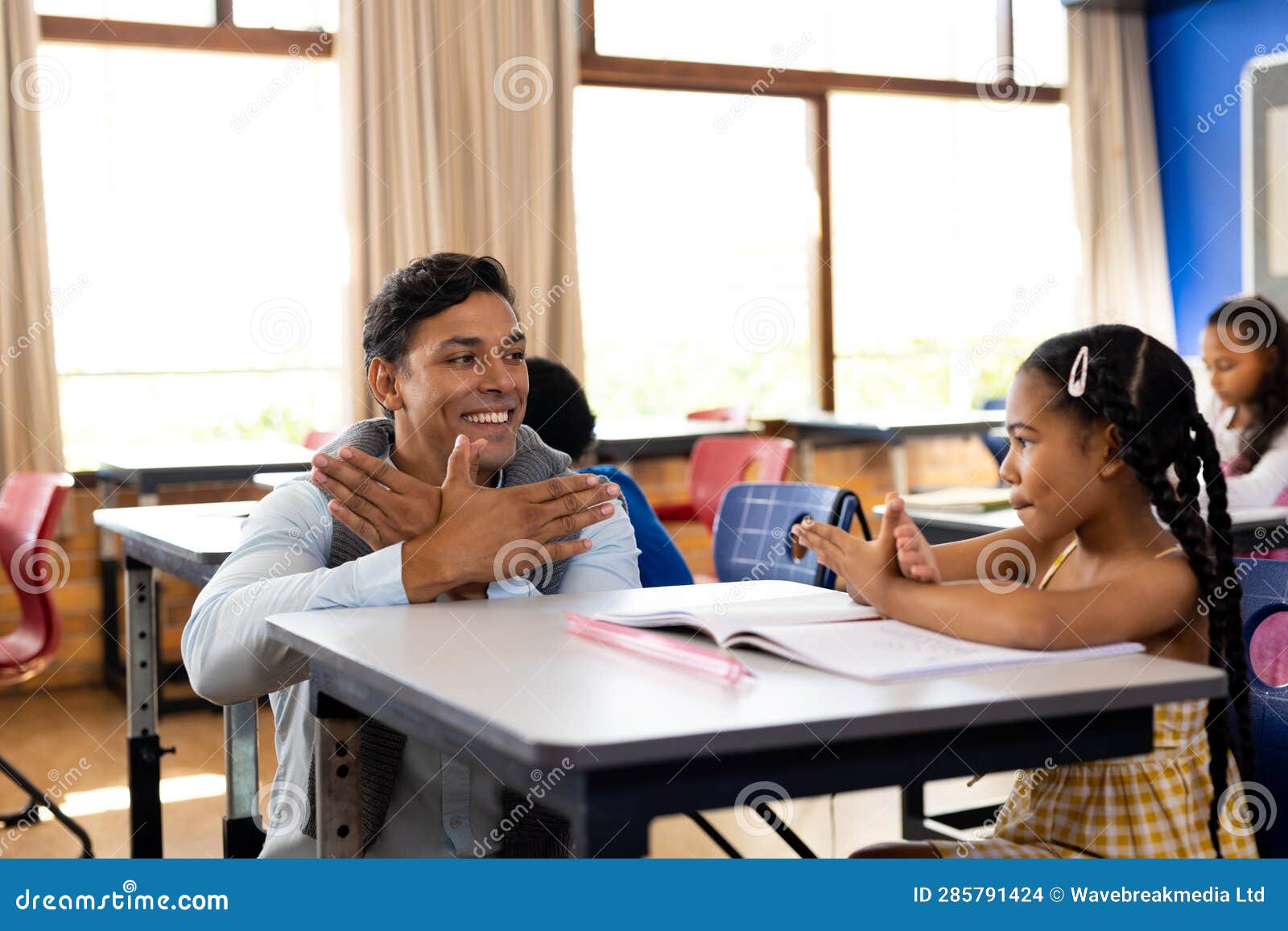 Diverse Male Teacher Teaching School Girl Using Sign Language in Class ...