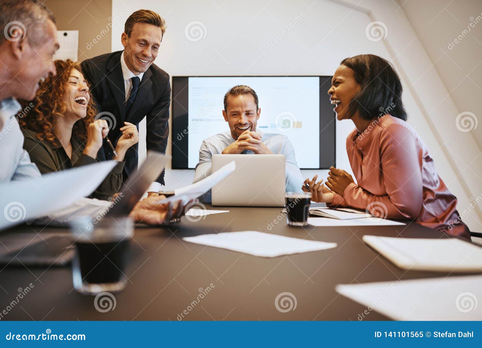 Diverse Work Colleagues Laughing Together During A Boardroom Mee Stock