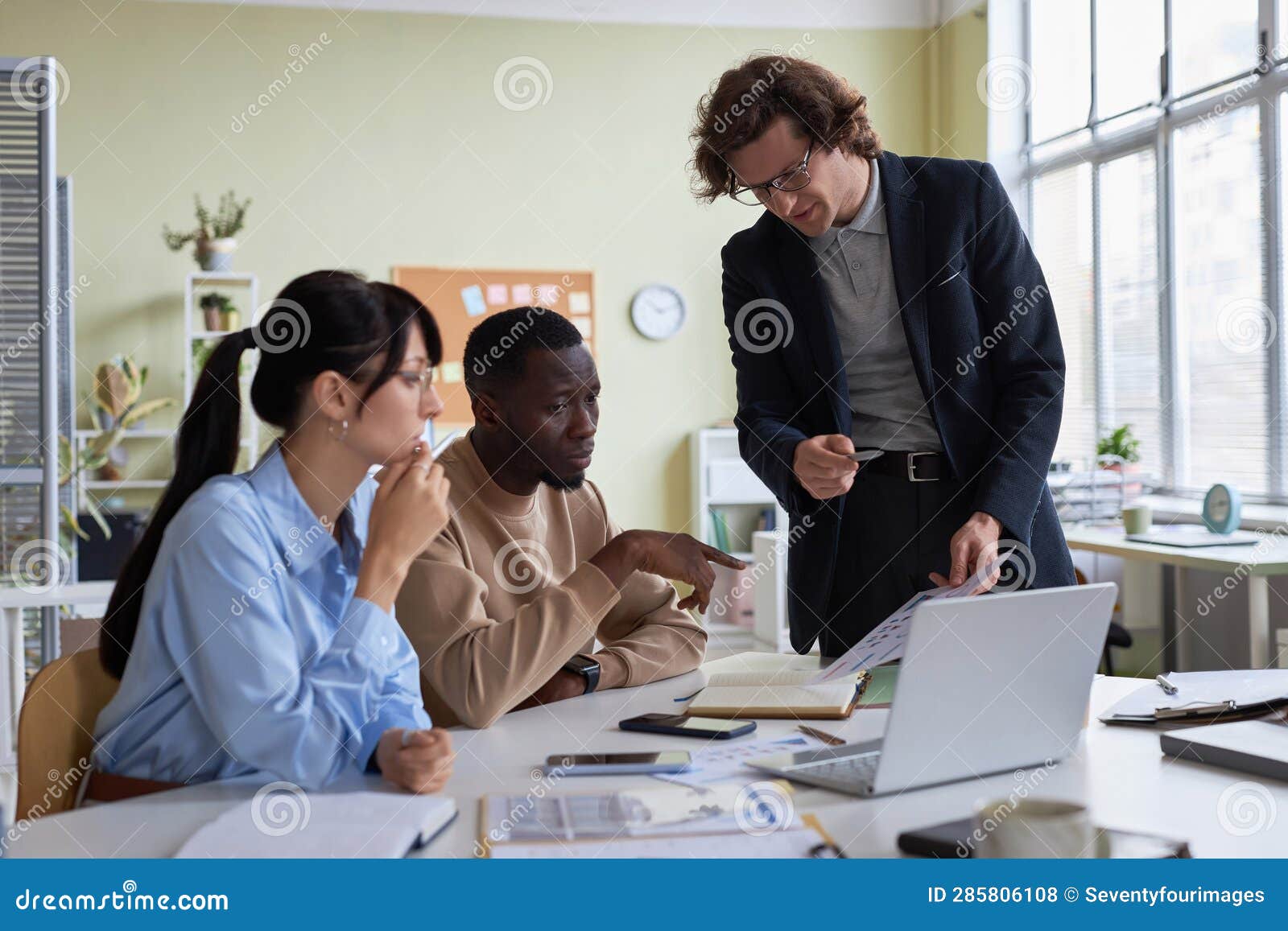 Diverse Young Business Team of Three People Collaborating on Project in ...