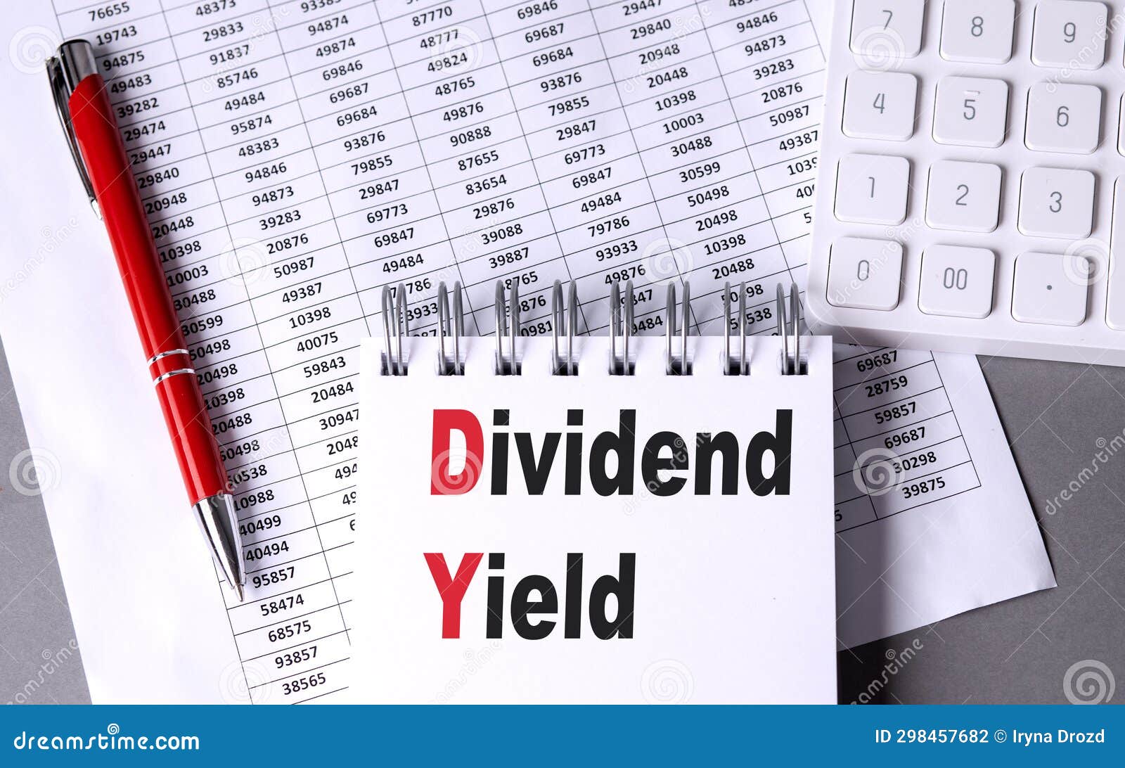 DIVIDEND YIELD Text on Notebook with Pen, Calculator and Chart on Grey ...