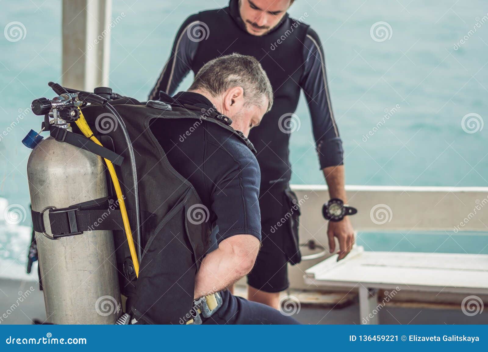 Diving Instructor Helps a Beginner Diver Prepare for Diving Stock Image ...