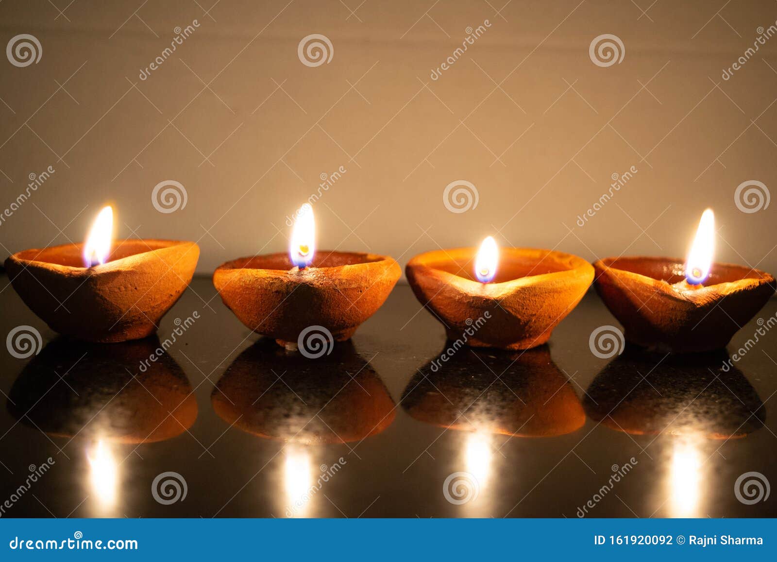 Diwali Diyas Lined Up in a Row on a Reflective Surface Stock Photo ...