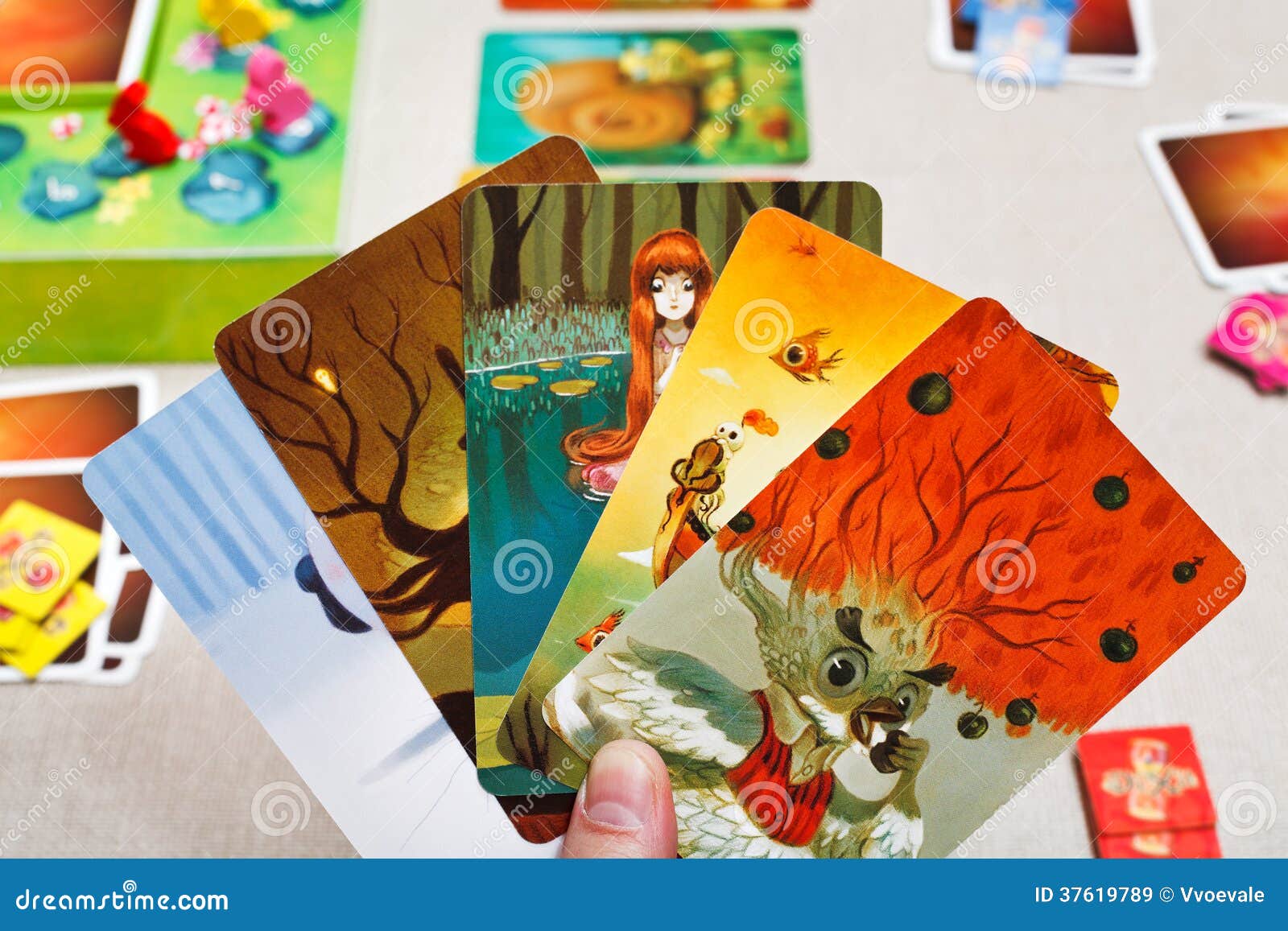 Dixit game cards in hand editorial stock image. Image of card - 37619789