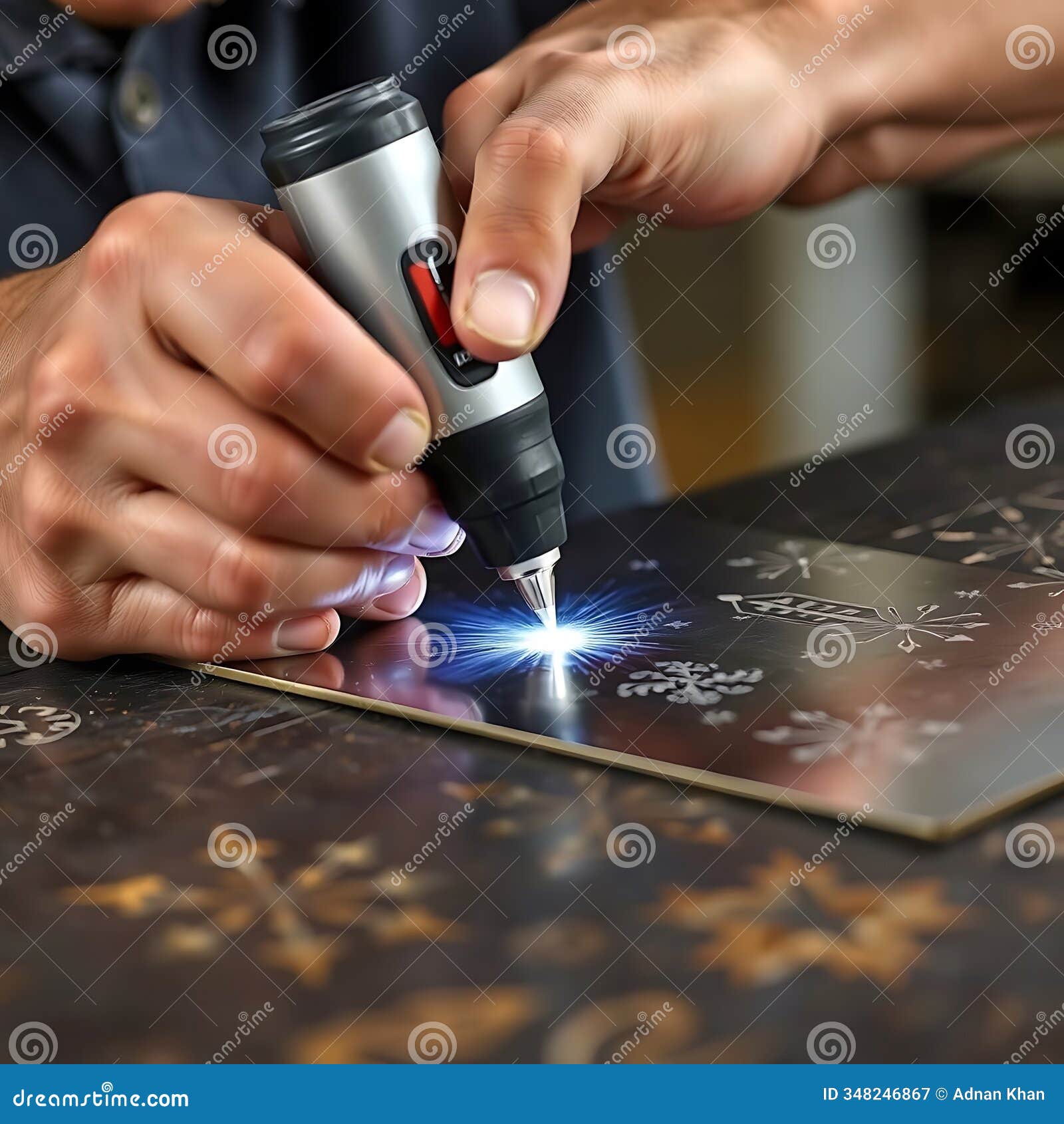 A DIY Enthusiast Using a Dremel Tool To Etch Patterns on a Metal Sheet ...
