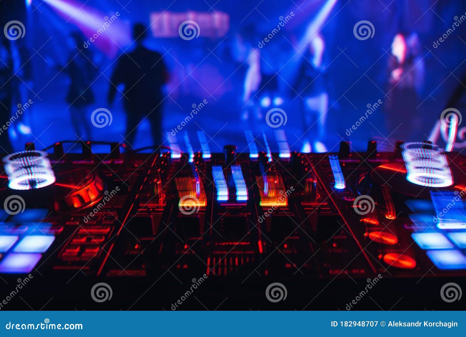 DJ Mixer in a Nightclub with Glowing Colored Lights from Controllers ...