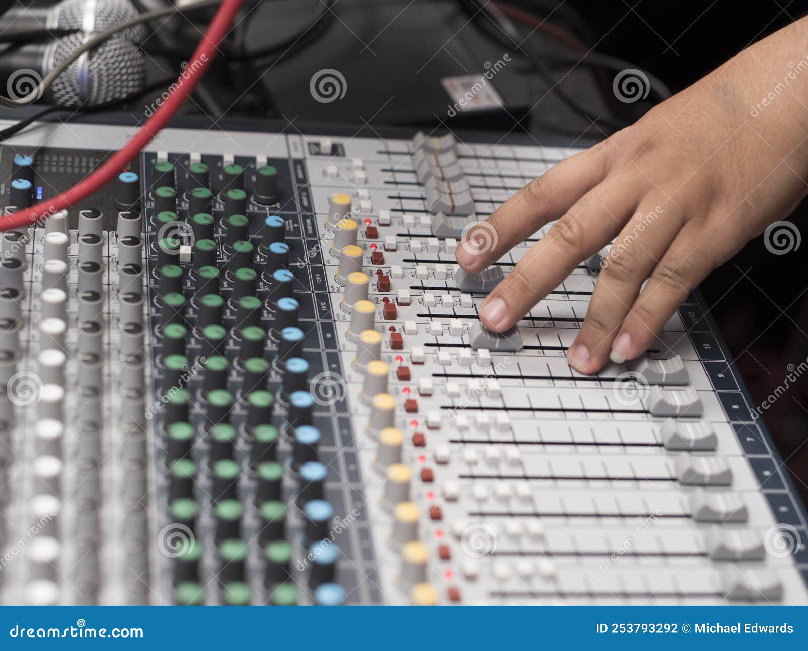 A DJ Operates a 16 Channel Digital Stereo Mixer. Adjusting the Channel ...