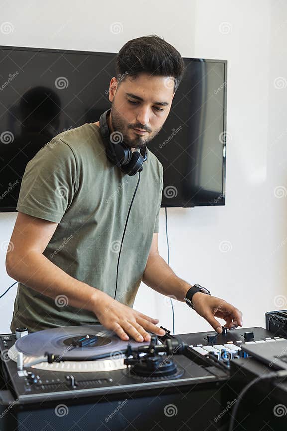 DJ Playing the Turntable while Music Plays in His Studio Stock Image ...