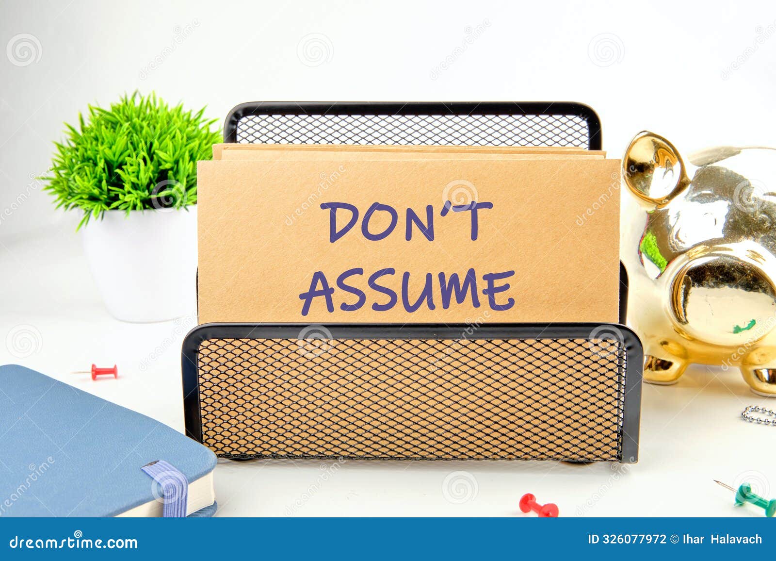 DO NOT ASSUME Text on a Postal Envelope in a Stand on a White ...