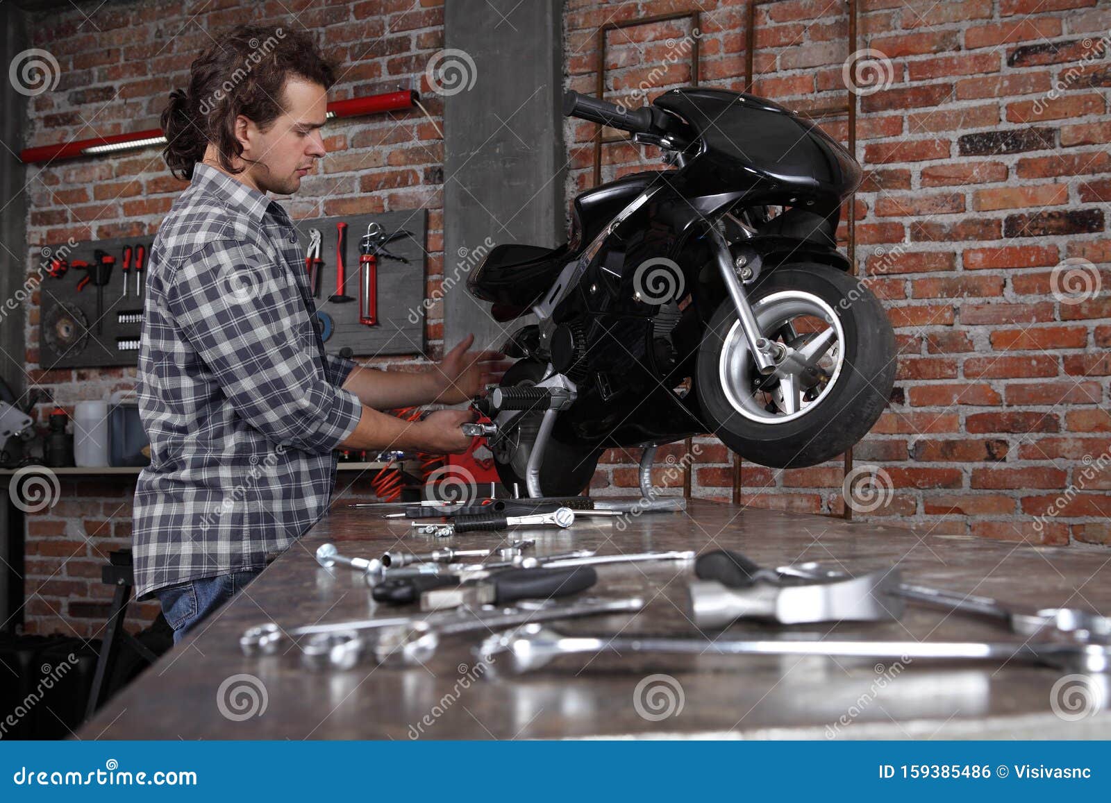 Do It Yourself, Young Man Repairing A Motorcycle In The Garage With Red ...