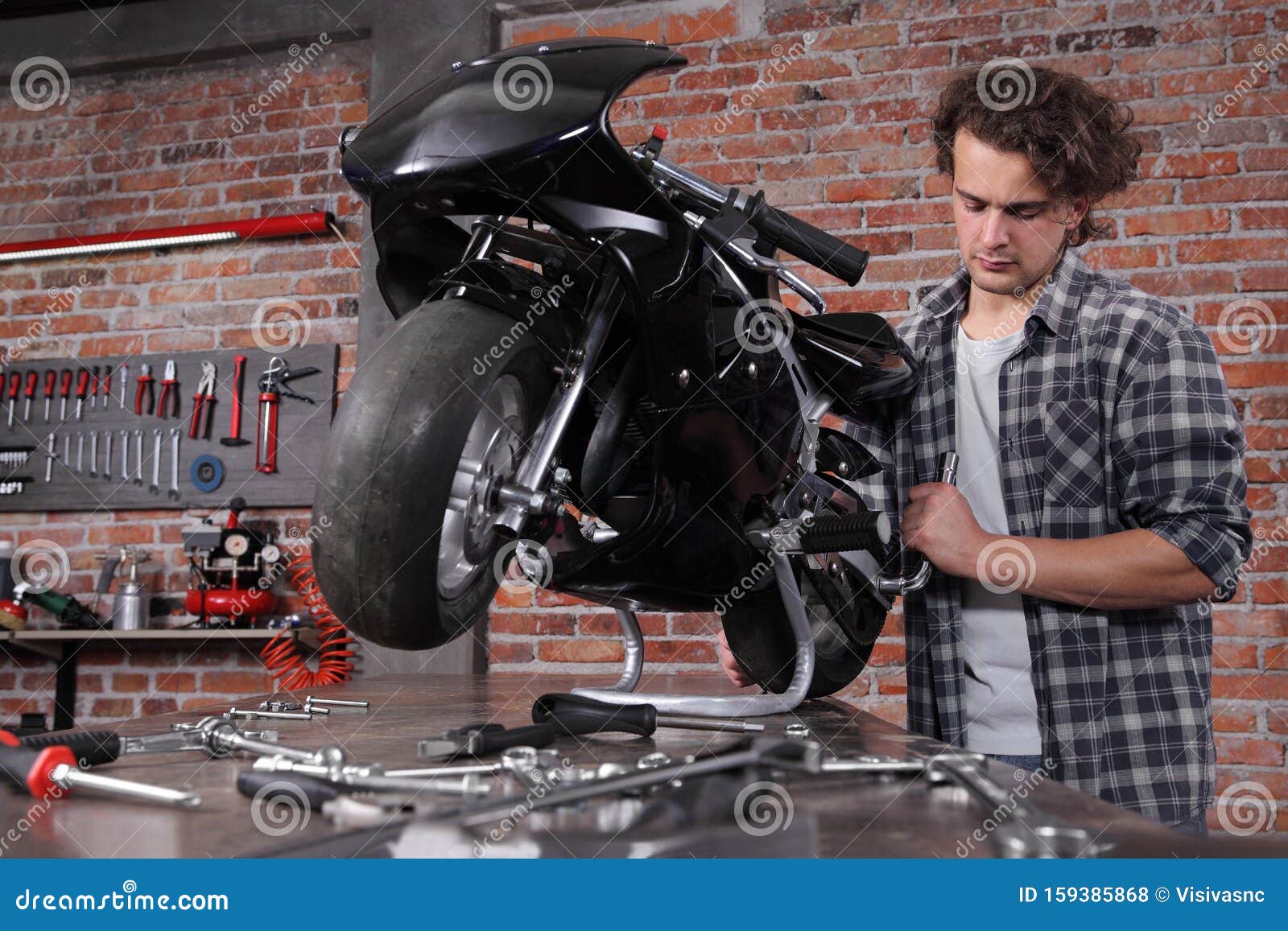Do it Yourself, Young Man Repairing a Motorcycle in the Garage with Red ...