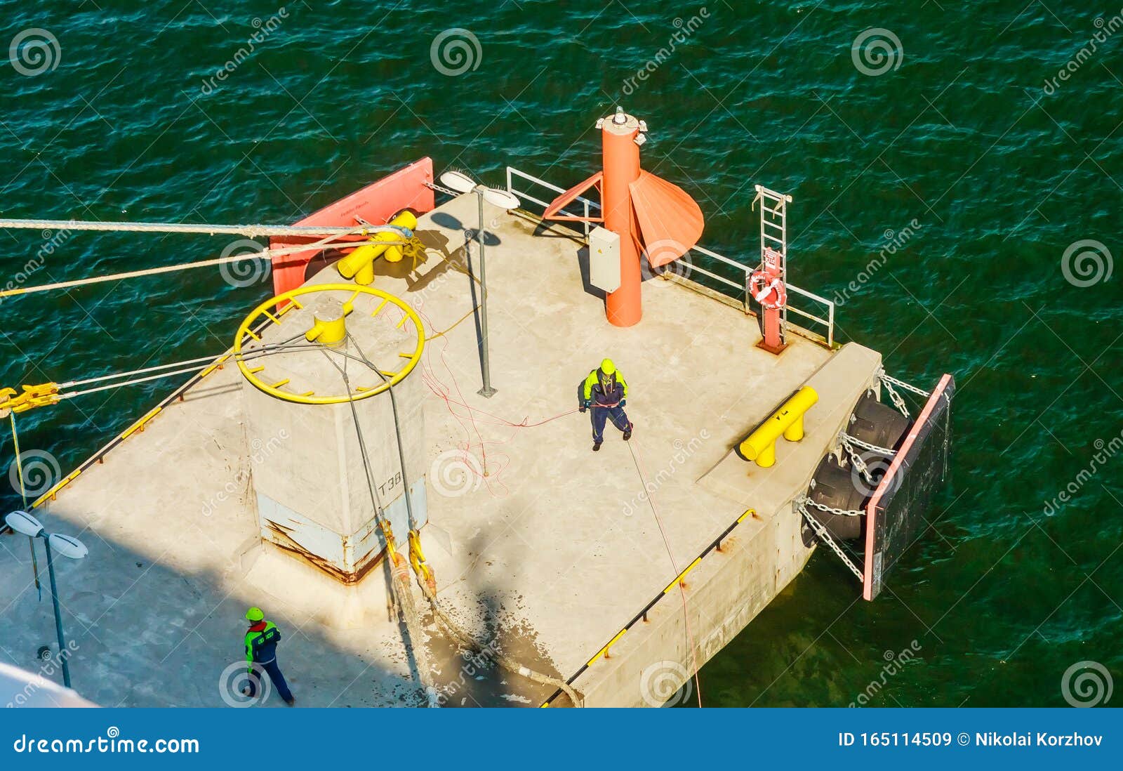 Dockworkers Attaching Moored Ship`s Hawser To Shoreside Bitt in Seaport ...