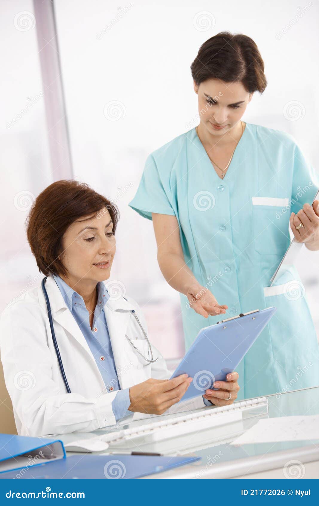 Doctor and Assistant Discussing Work Stock Photo - Image of holding ...