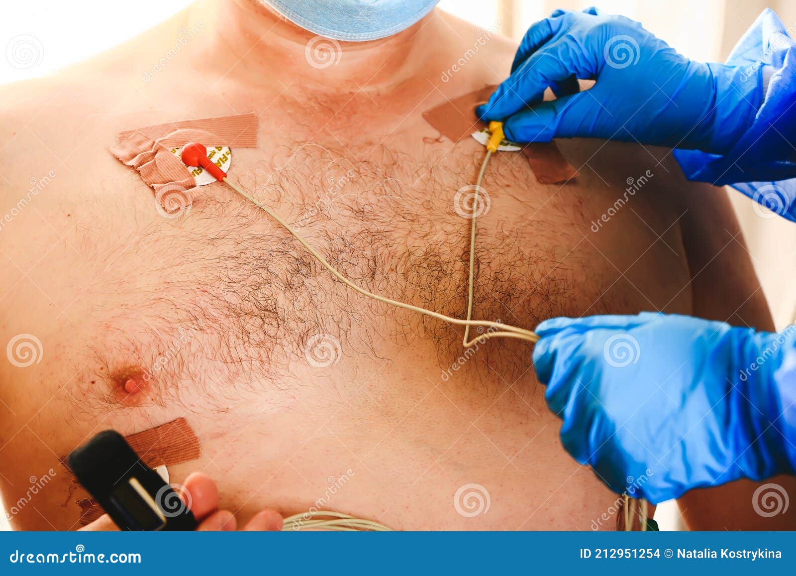 Doctor Attaches a Holter To the Man`s Chest. daily Monitoring of the ... Doctor Attaches a Holter To the Man`s Chest. daily Monitoring of the ...