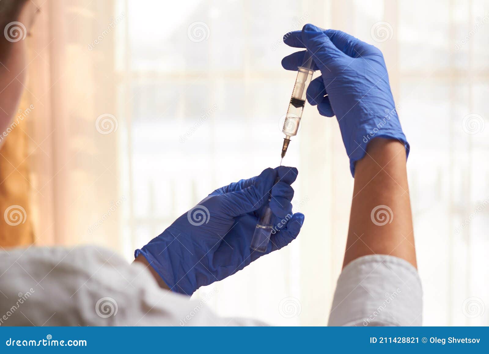A Doctor In Blue Medical Gloves Is Filling A Syringe With A Vaccine