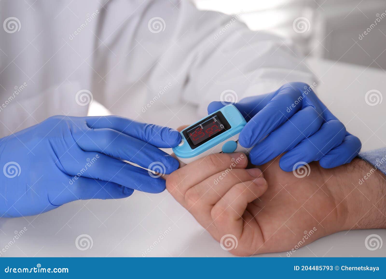 Doctor Checking Patient`s Oxygen Level with Pulse Oximeter at Light ...