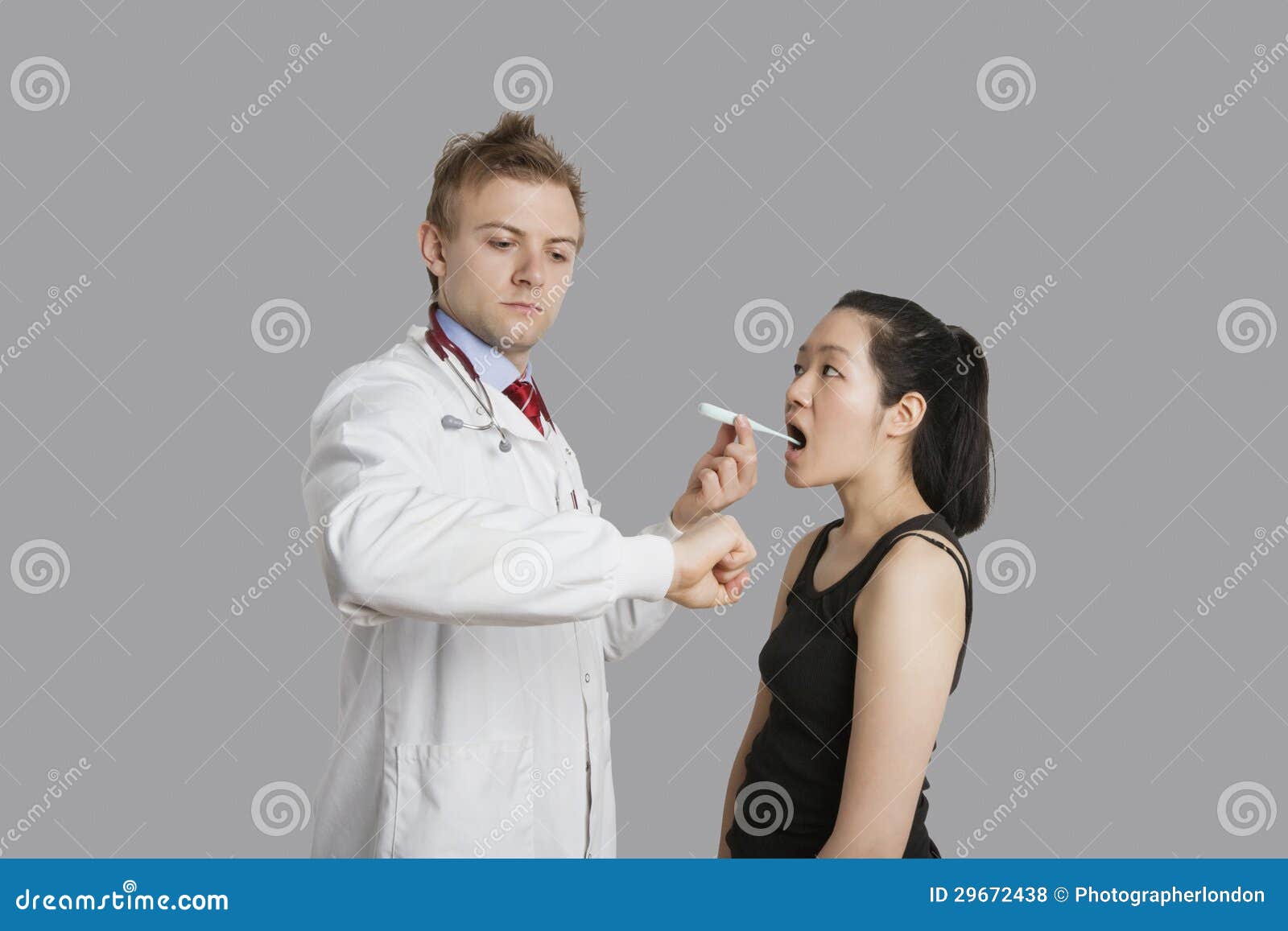 Doctor Checking Temperature of Female Patient Stock Photo - Image of ...