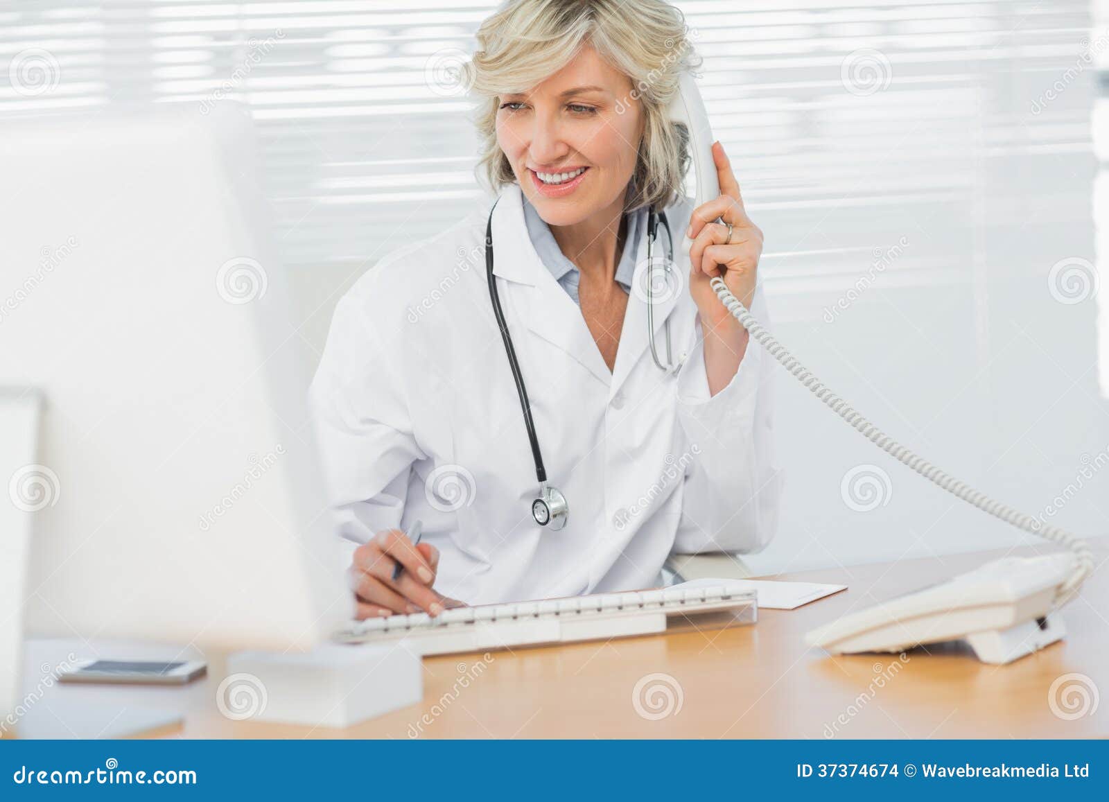 Doctor with Computer Using Phone at Medical Office Stock Photo - Image ...
