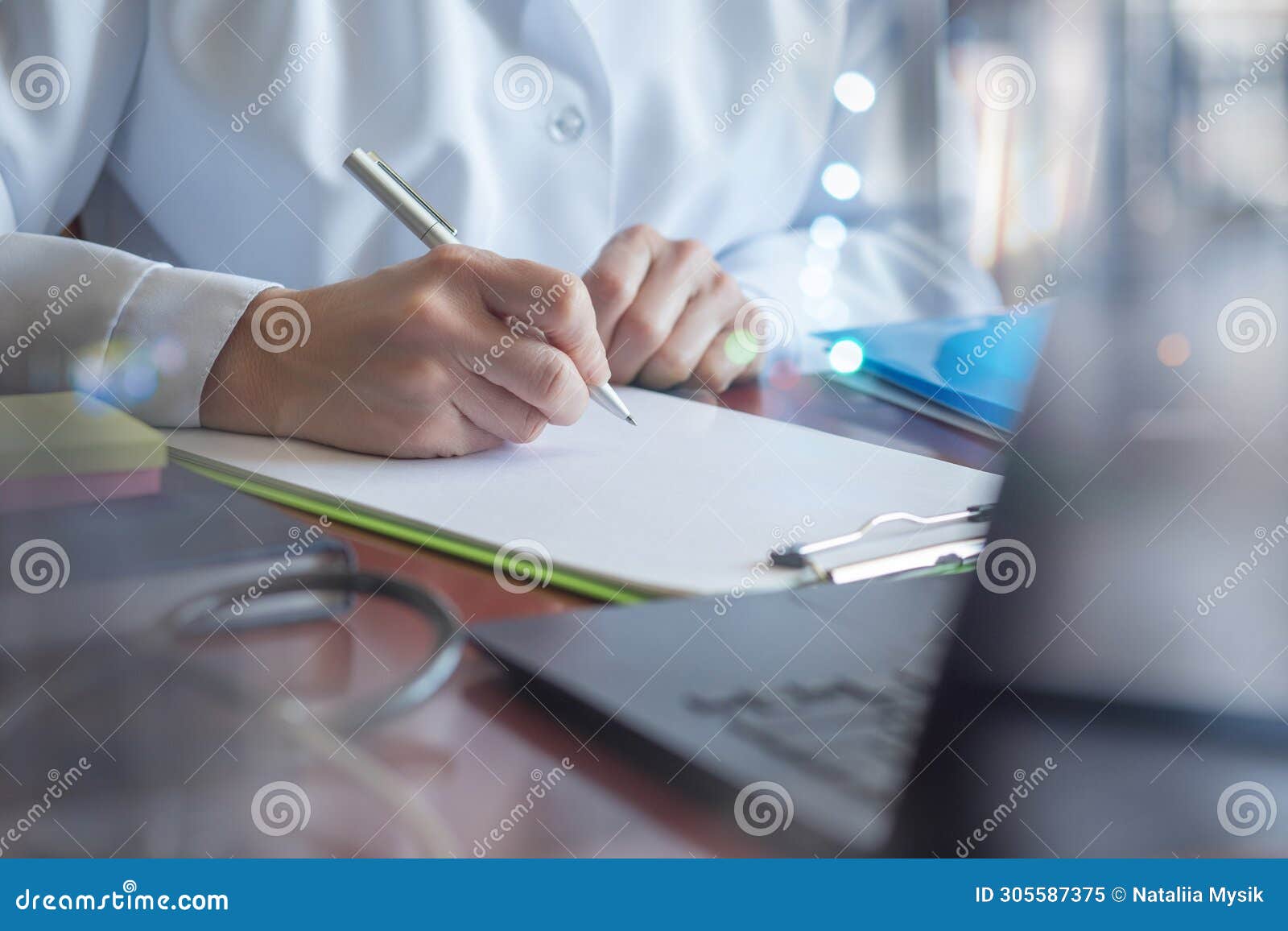 A Doctor is Filling Out Paperwork at a Desk in a Office Stock Image ...