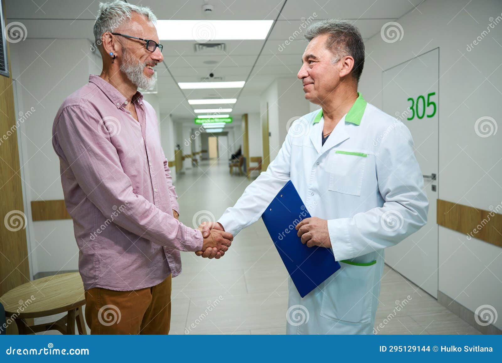 Doctor Greets a Man in a Bright Hospital Corridor Stock Photo - Image ...