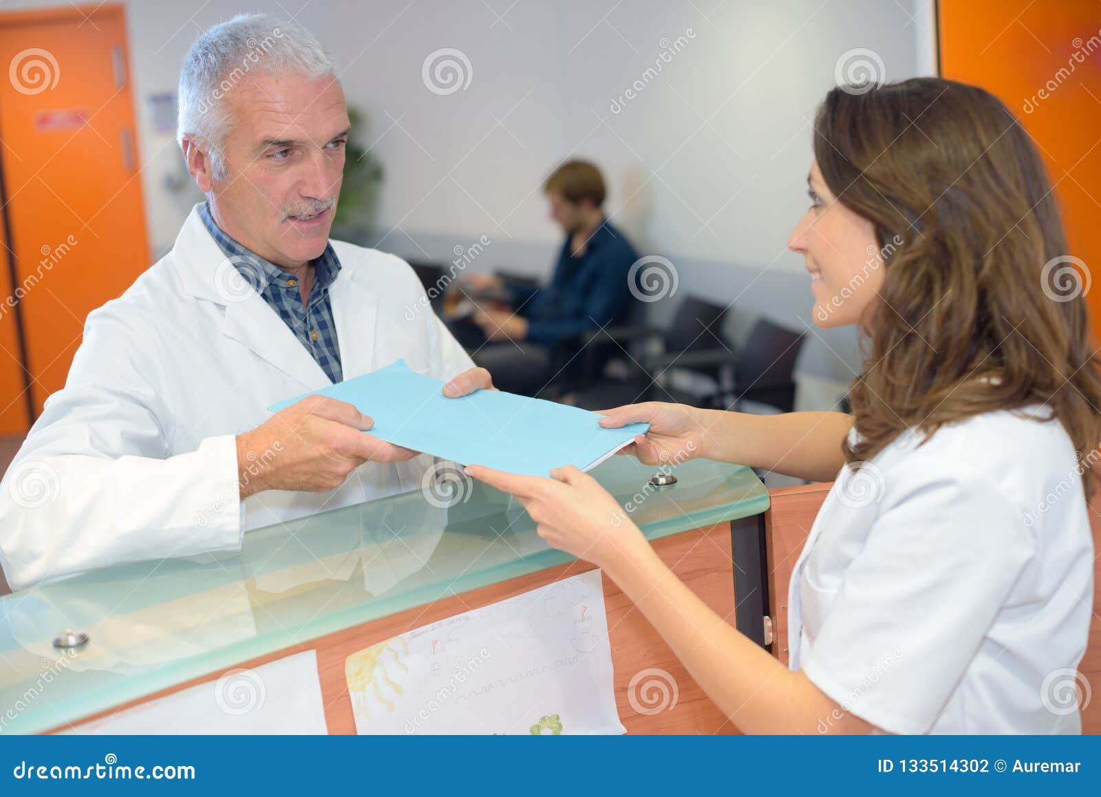 Doctor Handing File To Receptionist Stock Photo - Image of doctor, desk ...