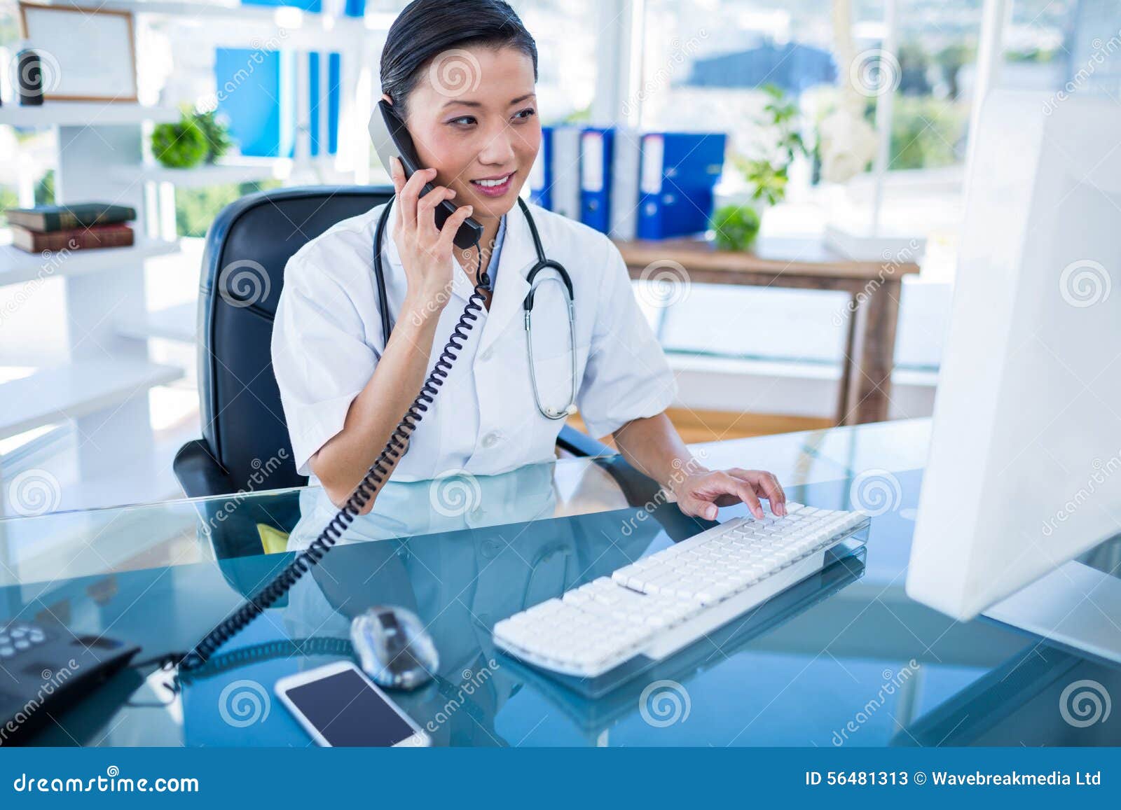 Doctor Having Phone Call and Using Her Computer Stock Image - Image of ...