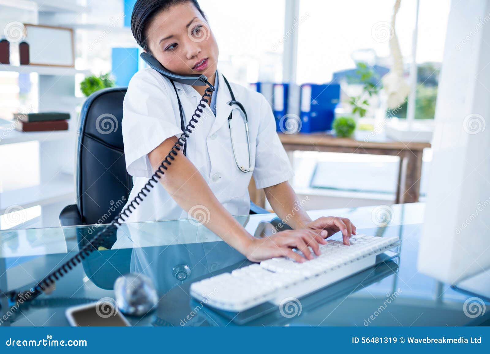Doctor Having Phone Call and Using Her Computer Stock Image - Image of ...