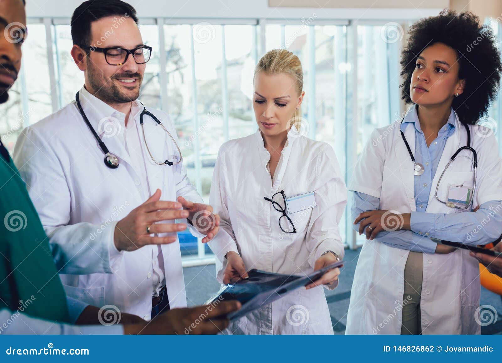 Doctor Holding Up an X-ray with Fellow Doctors Stock Photo - Image of ...