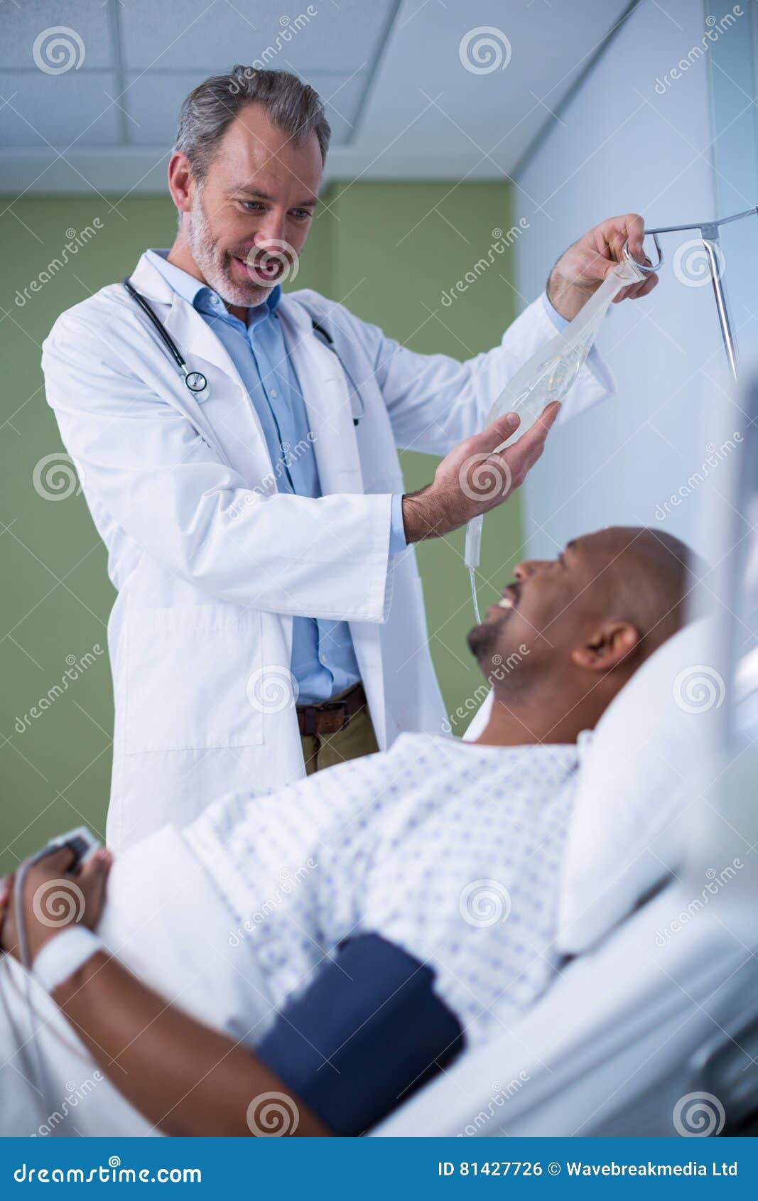 Doctor Interacting with Patient while Adjusting Iv Drip Stock Photo ...