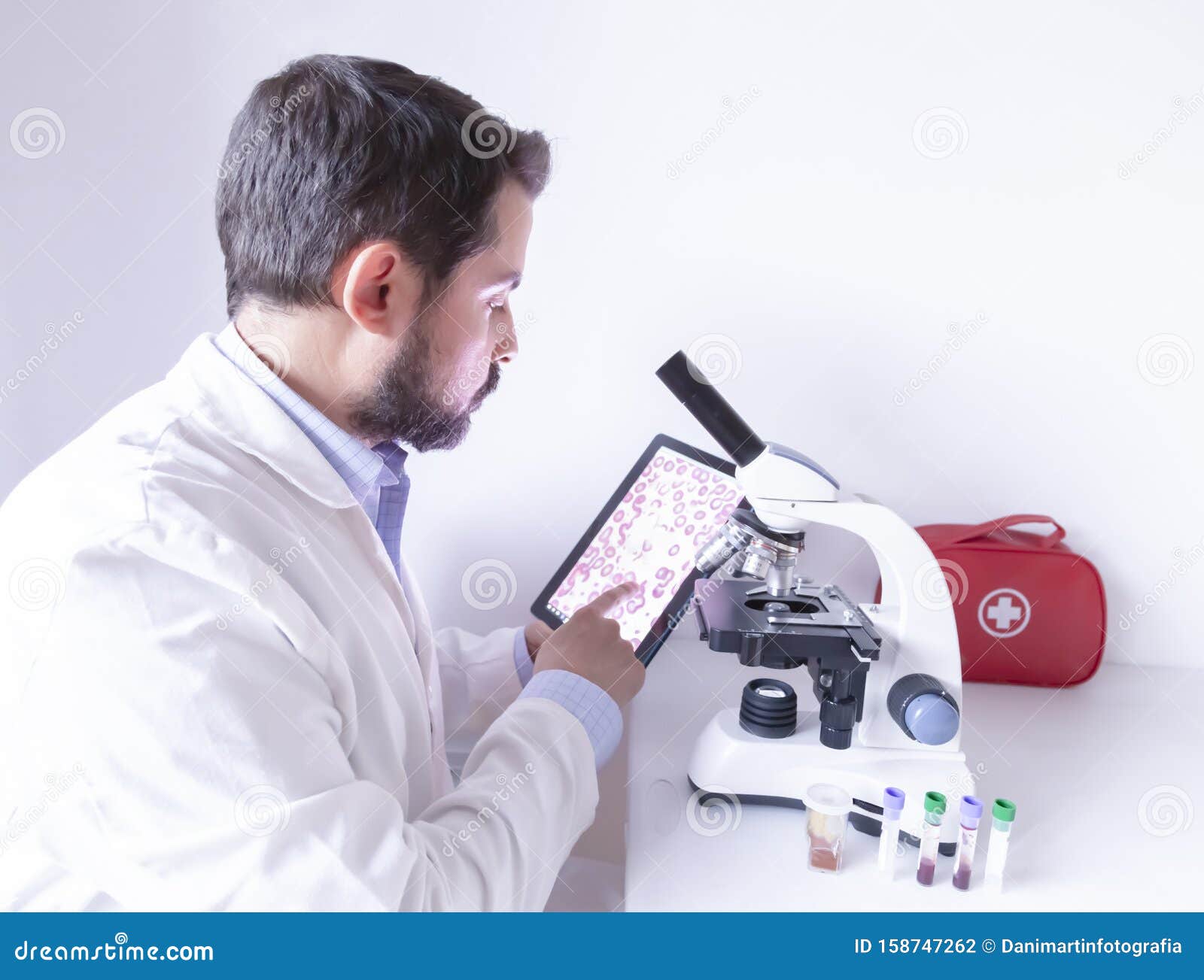 Doctor Looking on Digital Tablet Computer and Working on Microscope in ...