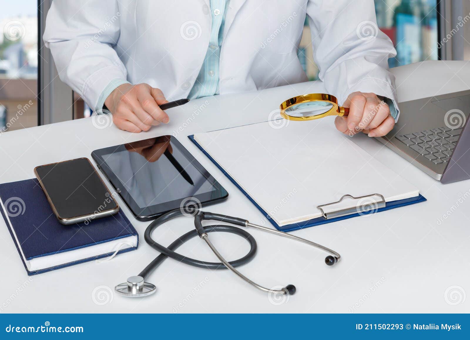 Doctor Looks with a Magnifying Glass at a Document in His Office Stock ...