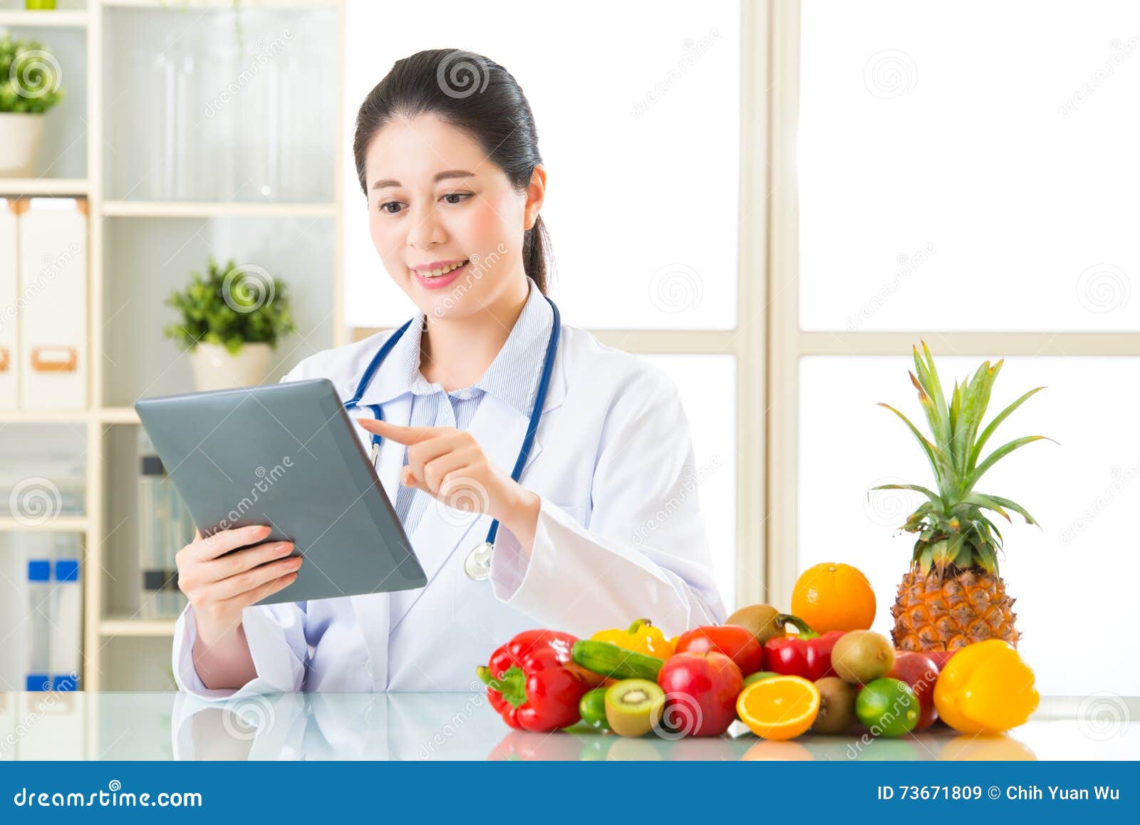 Doctor Nutritionist Using Digital Tablet With Fruits And Vegetable
