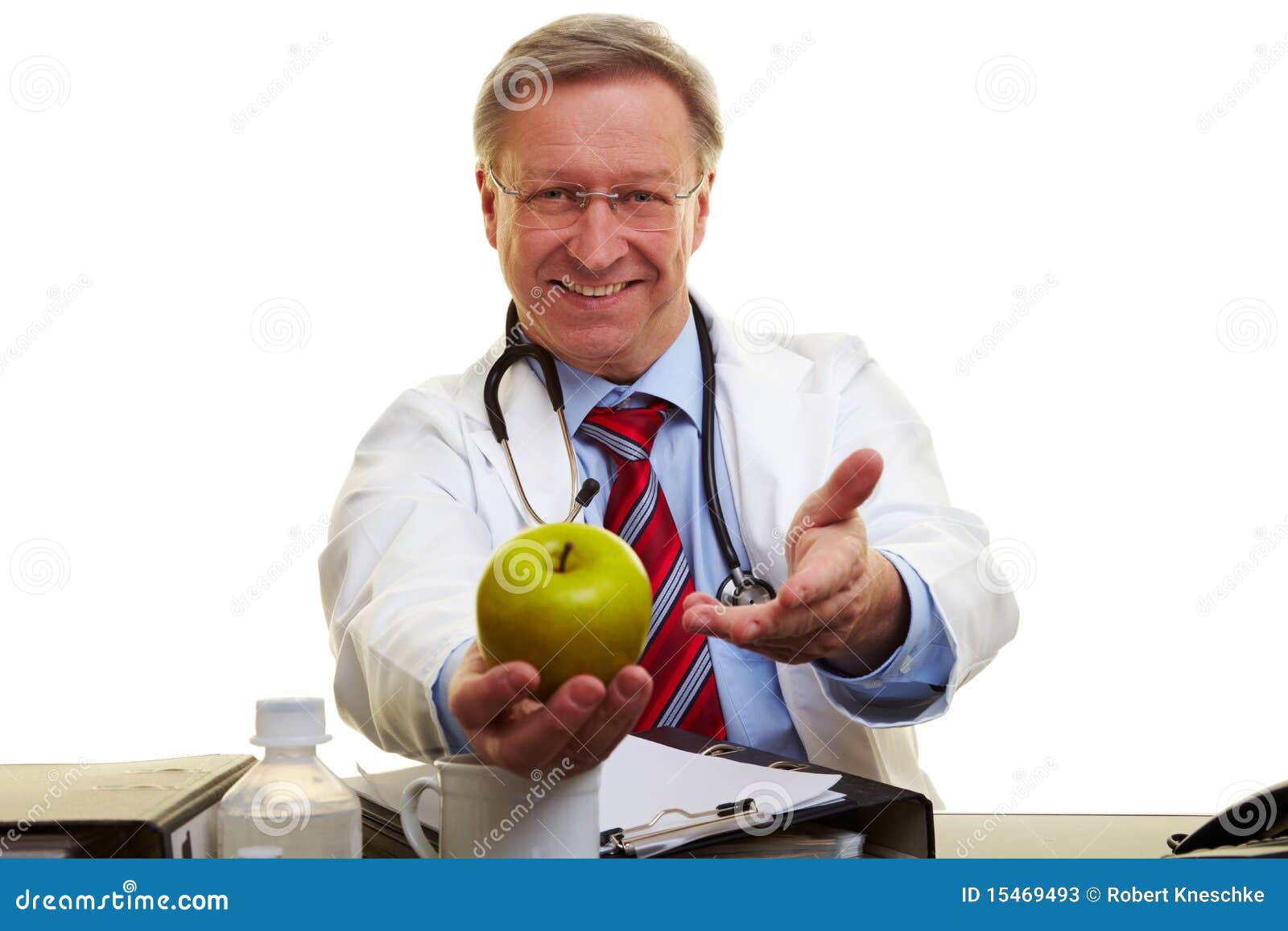 Doctor offering an apple stock image. Image of desk, clinic - 15469493