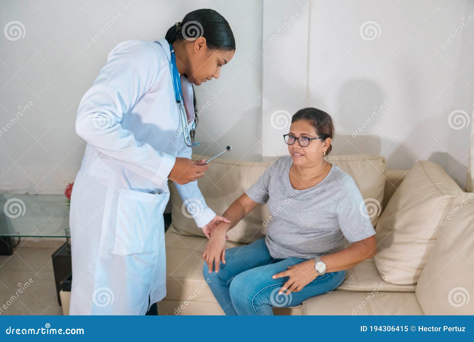 Neurological Examination. The Neurologist Testing Hand Reflexes On A ...