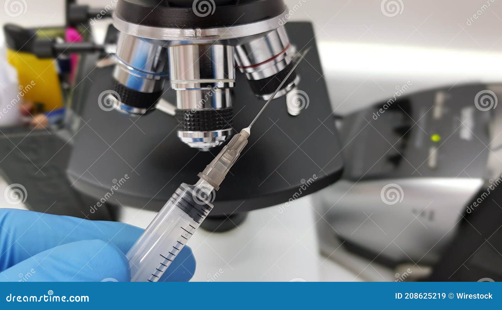 Doctor Preparing Syringe in a Medical Setup with a Microscope in the ...