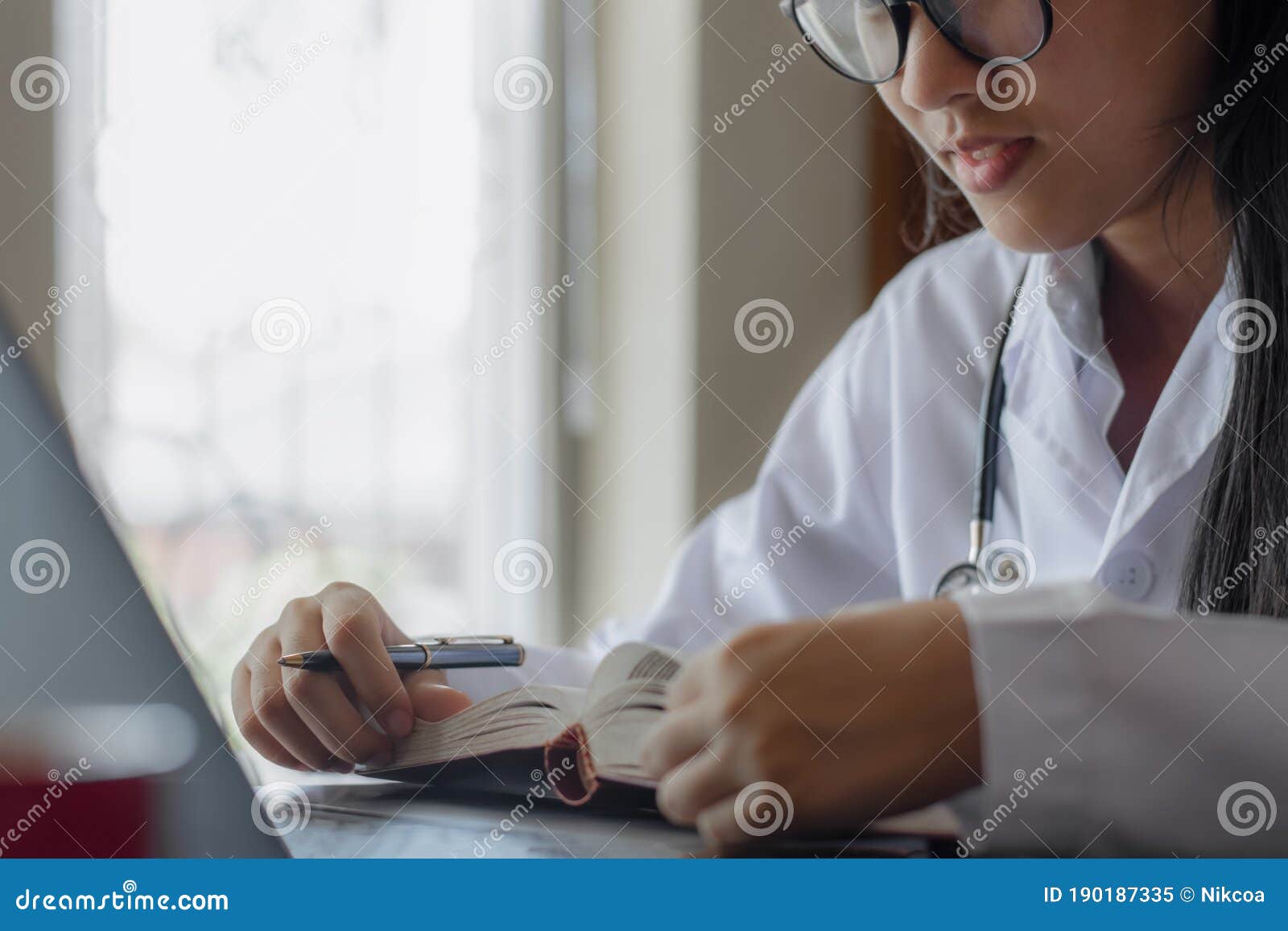 Young Asian Medical Student or Doctor Woman with Glasses Read Book ...
