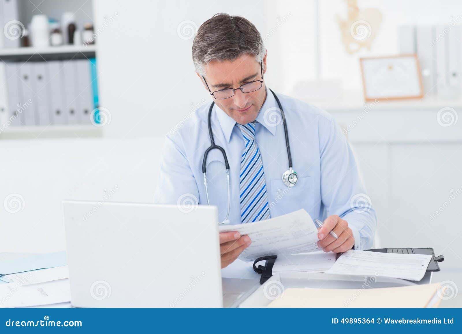 Doctor Reading Document at Table Stock Photo - Image of professional ...