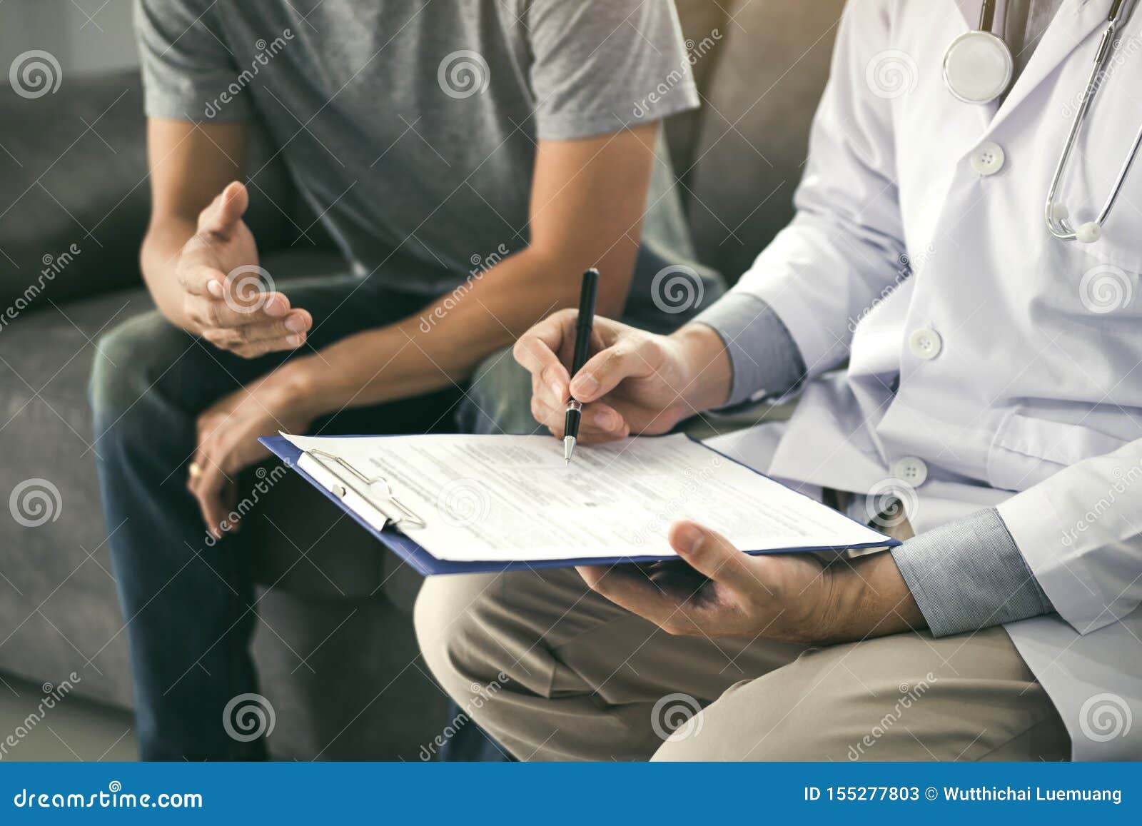 Doctor is Recording the Patient`s Information while the Patient is ...