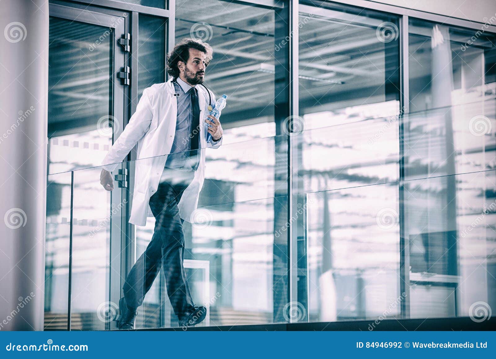 Doctor rushing in corridor stock photo. Image of attractive - 84946992