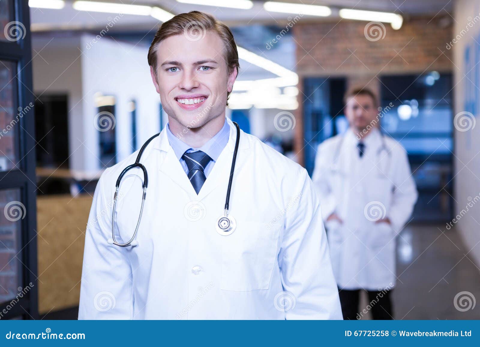 Doctor smiling in hospital stock photo. Image of male - 67725258